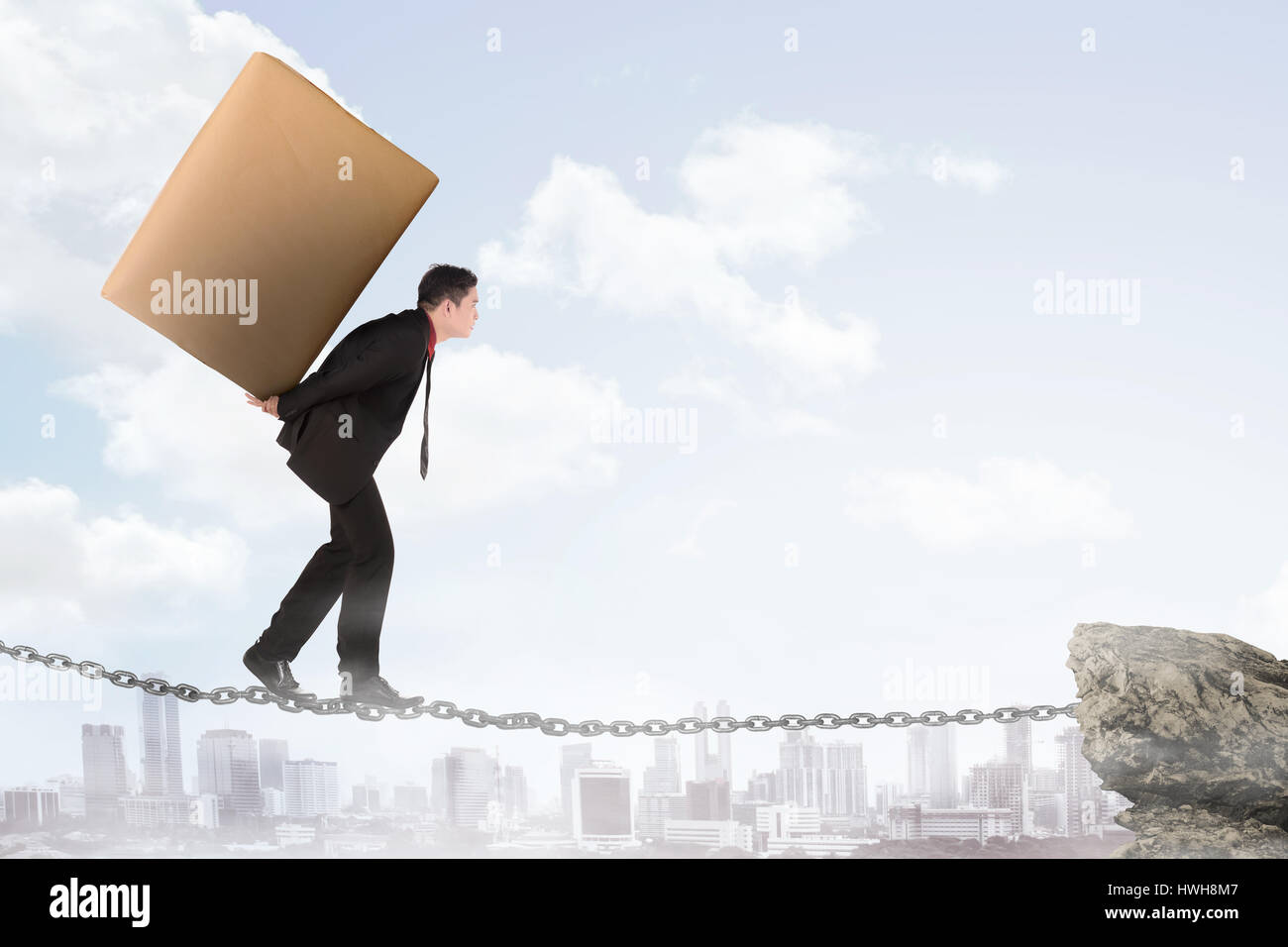 Business man carry heavy package, walking on the chain Stock Photo - Alamy