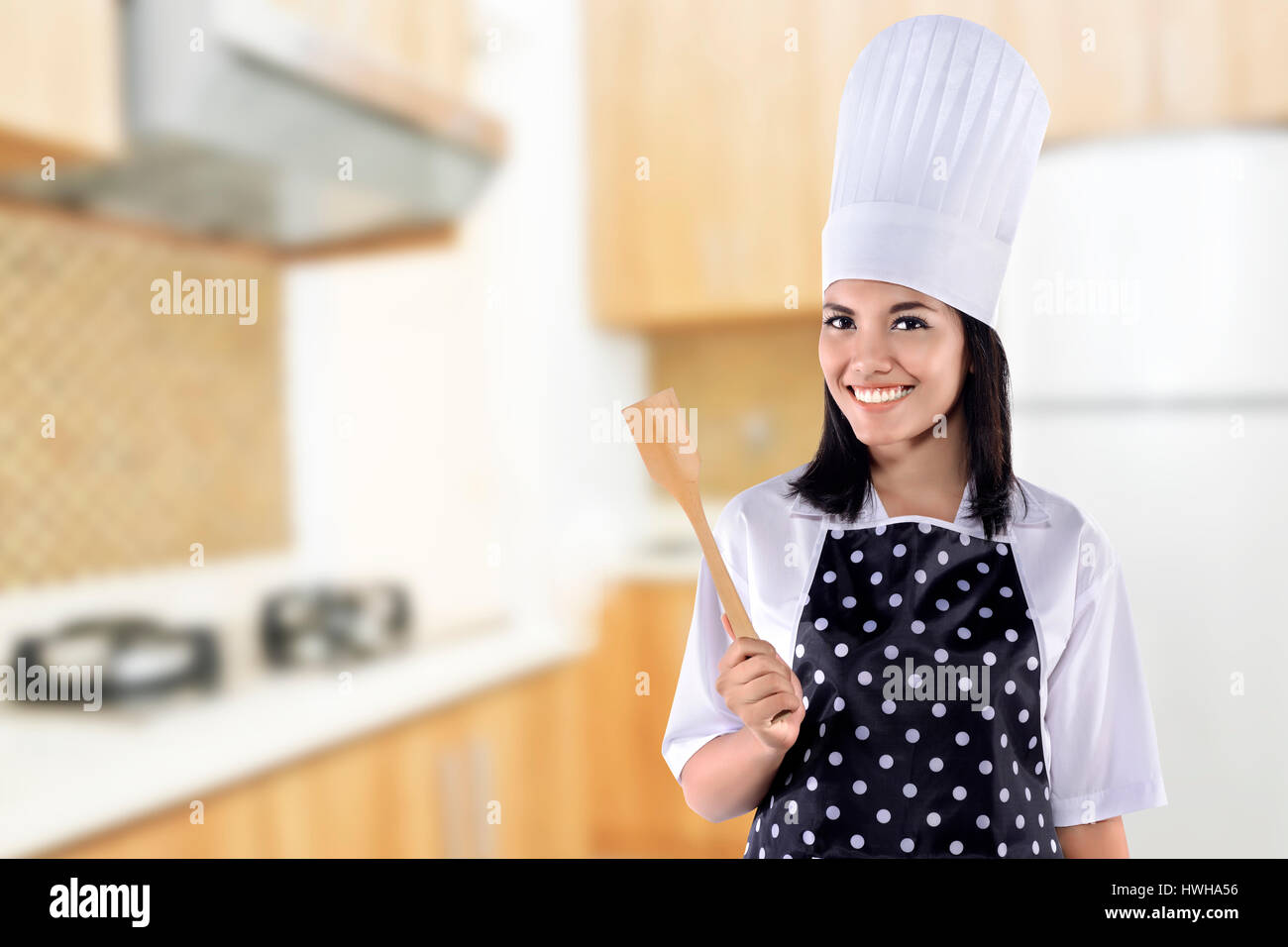 Portrait of young woman chef over kitchen background Stock Photo - Alamy