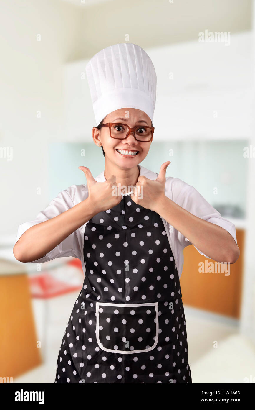 Portrait of young woman chef over kitchen background Stock Photo - Alamy