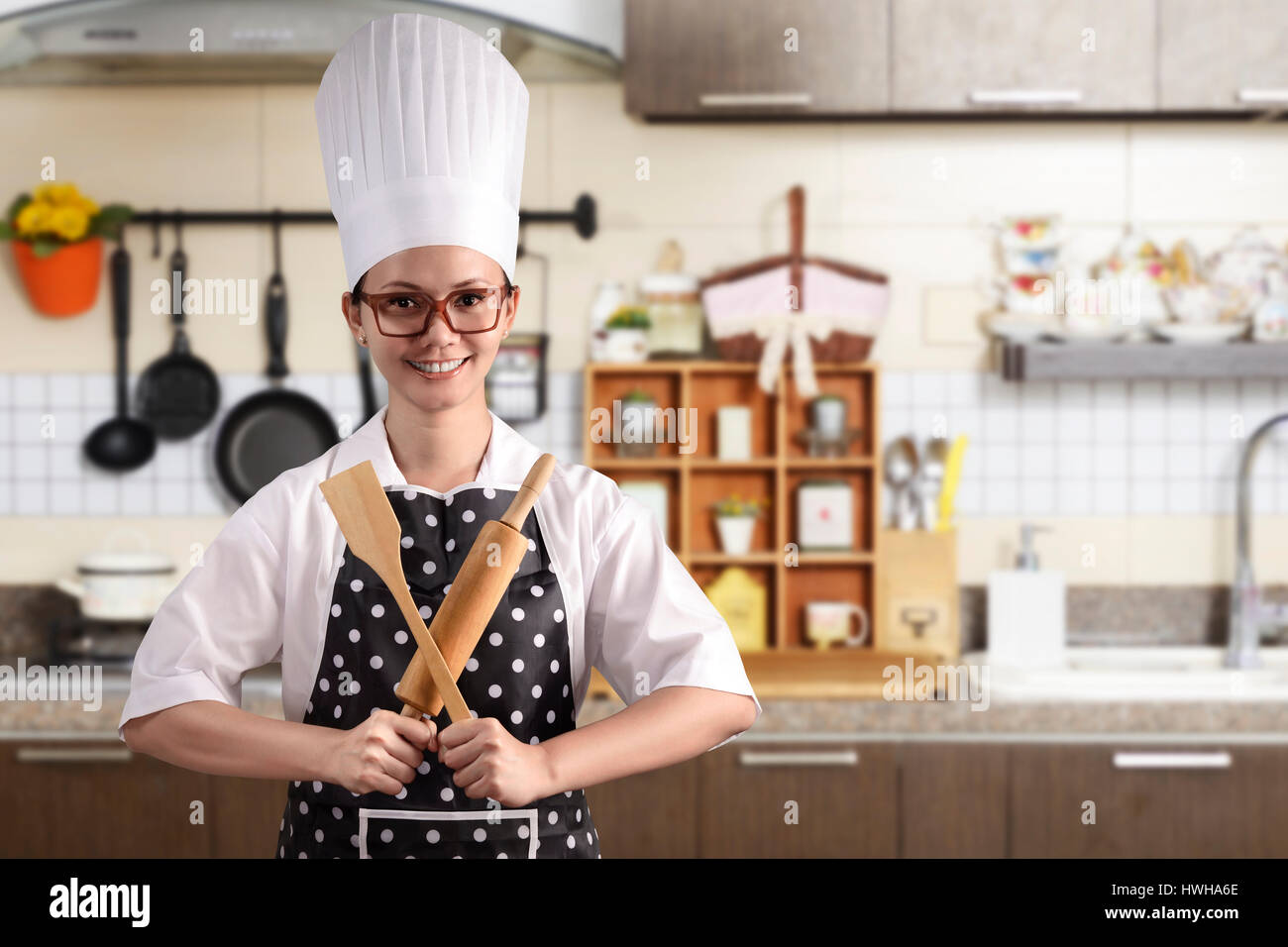 Portrait of young woman chef over kitchen background Stock Photo - Alamy