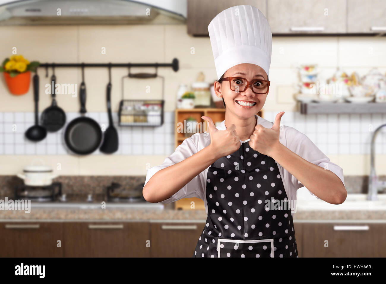Portrait of young woman chef over kitchen background Stock Photo - Alamy