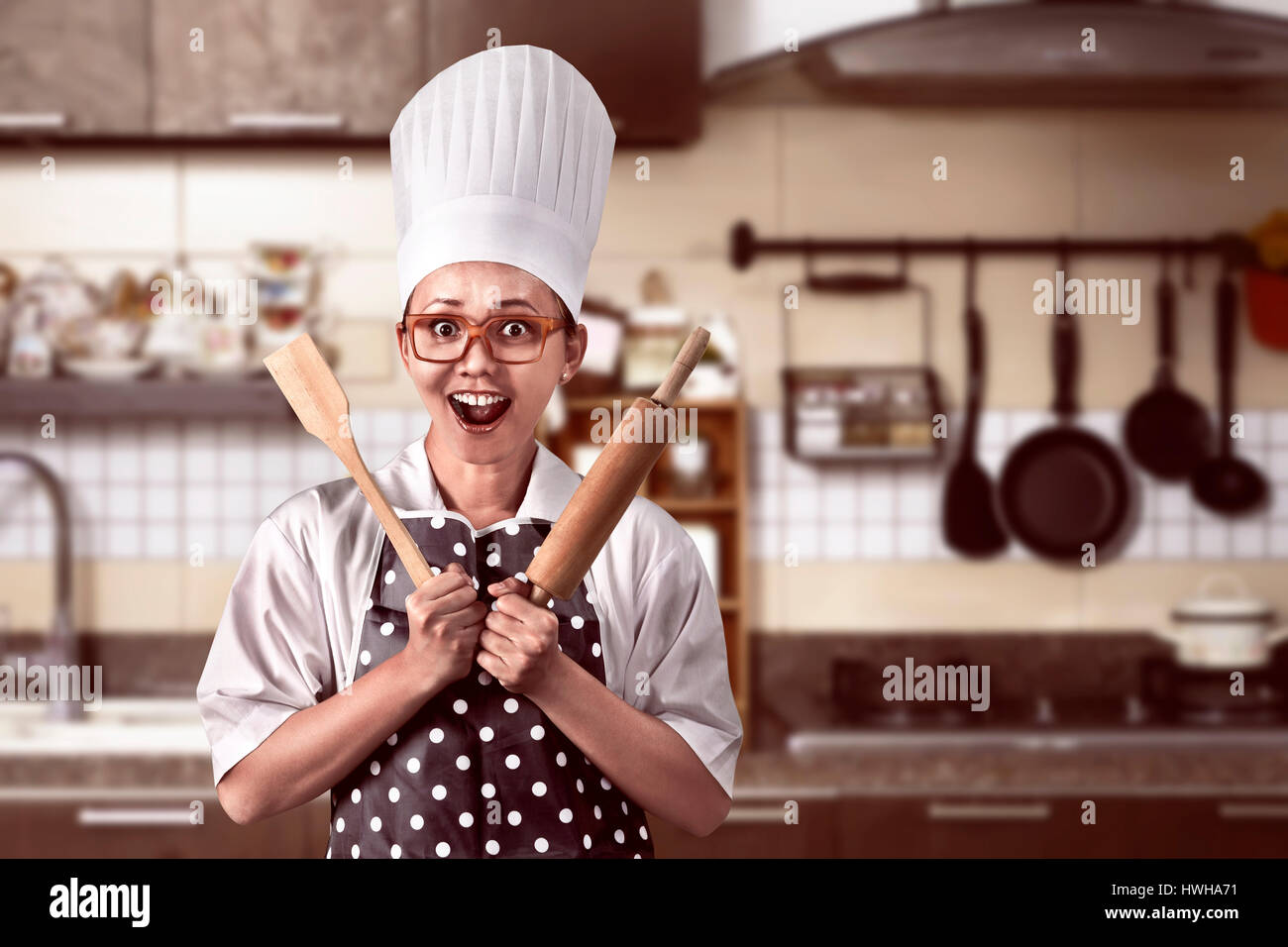 Portrait of young woman chef over kitchen background Stock Photo - Alamy