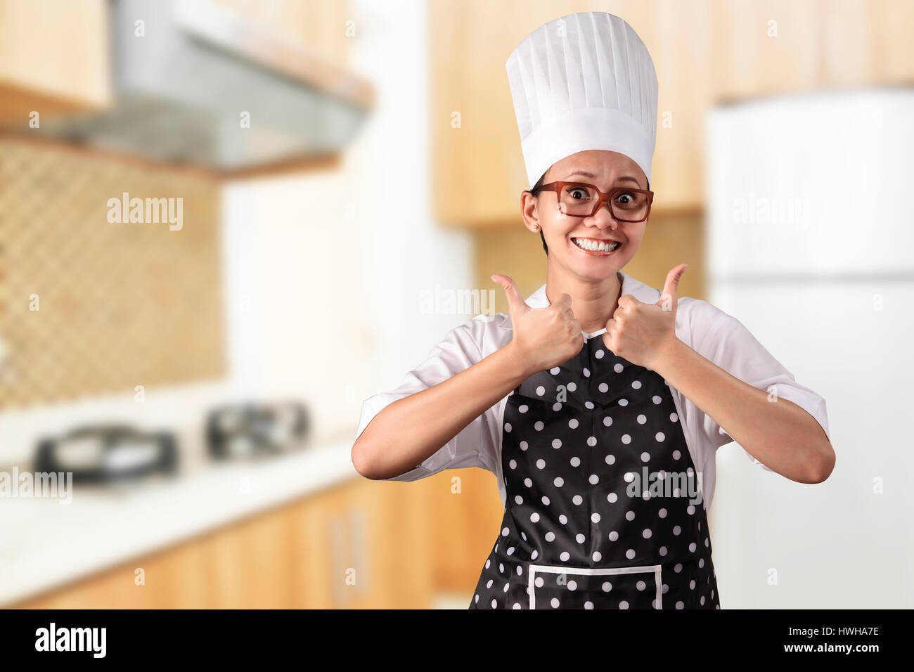 Portrait of young woman chef over kitchen background Stock Photo - Alamy