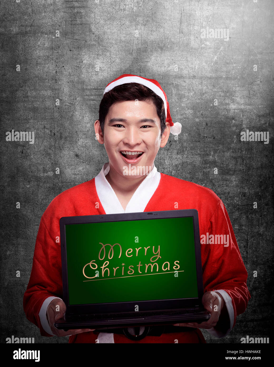 Handsome asian man wearing costume as santa claus and holding laptop ...
