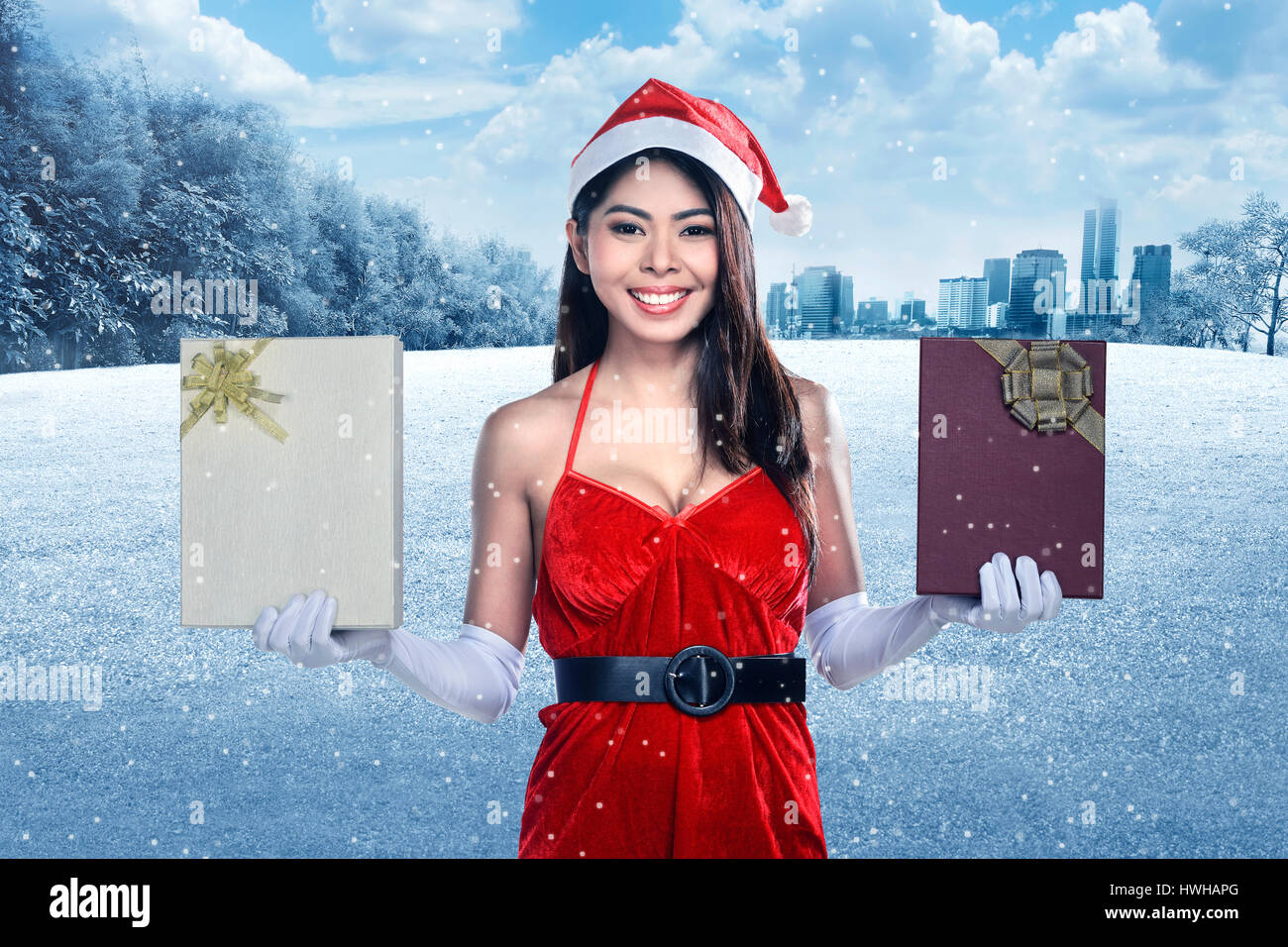 Beautiful asian santa woman holding gift box with winter background ...
