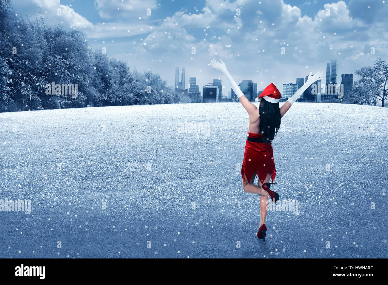 Back view of young woman wearing santa claus costume on the winter ...
