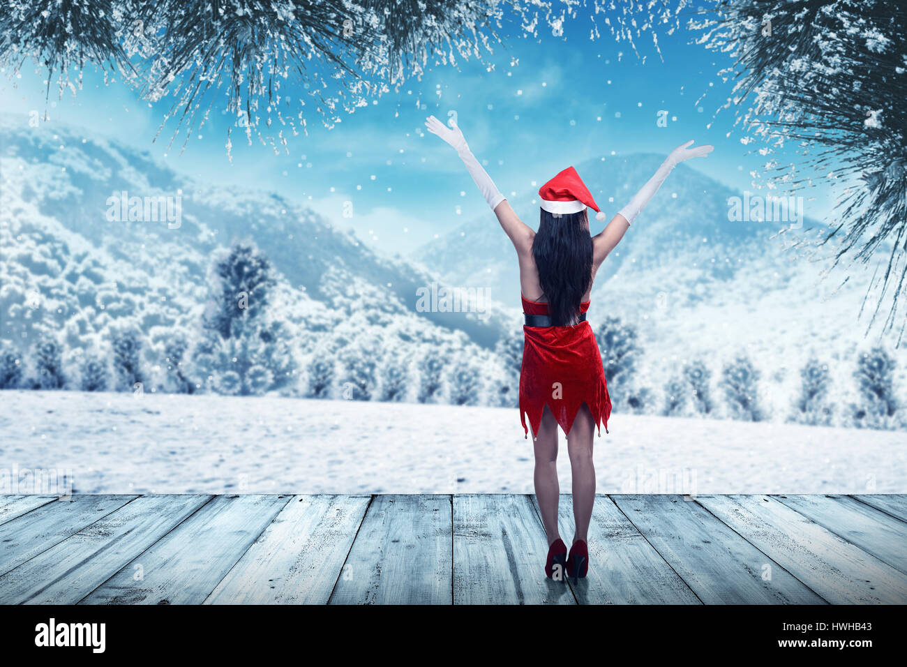 Back view of young woman wearing santa claus costume on the winter ...