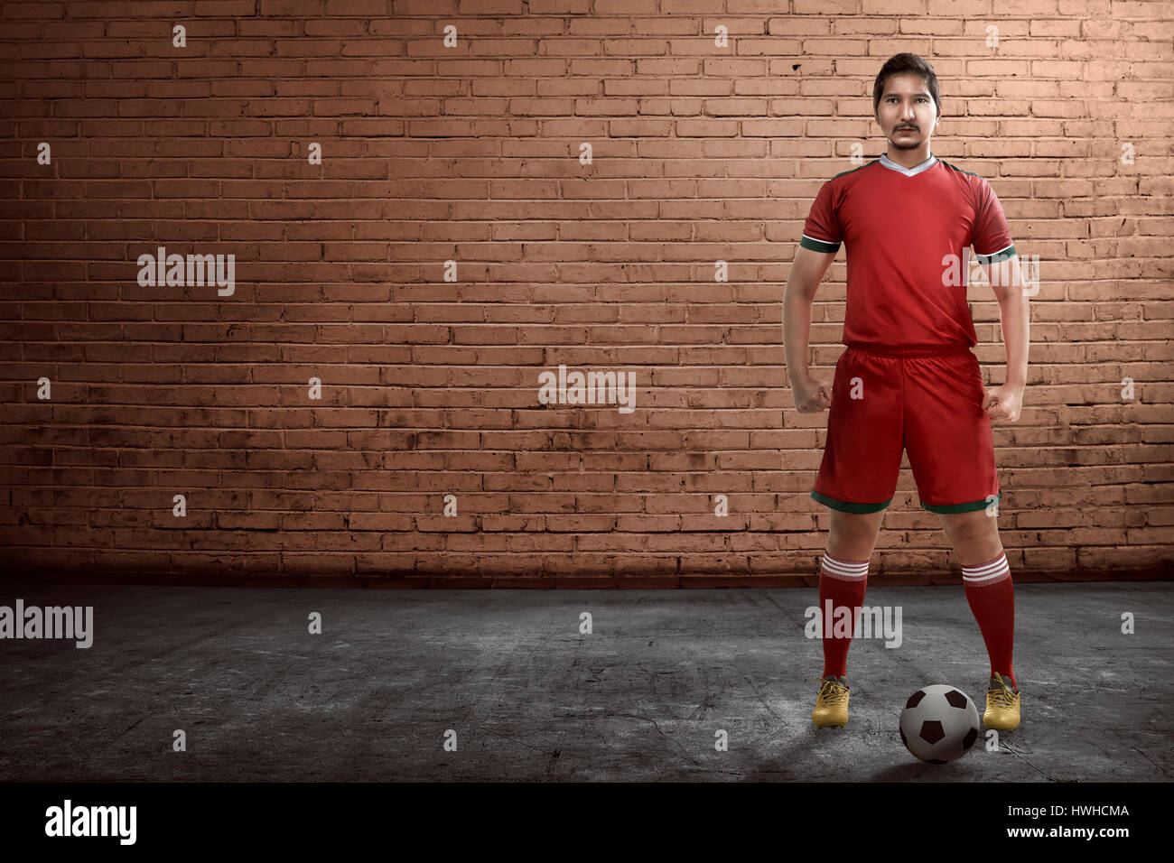 Asian football player standing on the alley ready playing street soccer ...