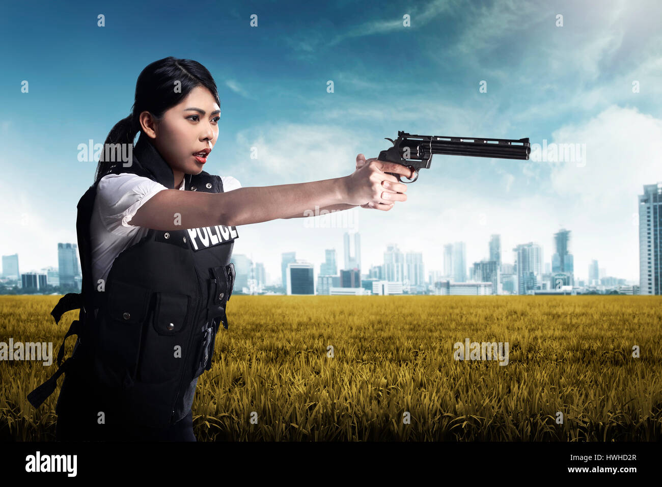 Beautiful police woman holding gun ready to fire Stock Photo - Alamy