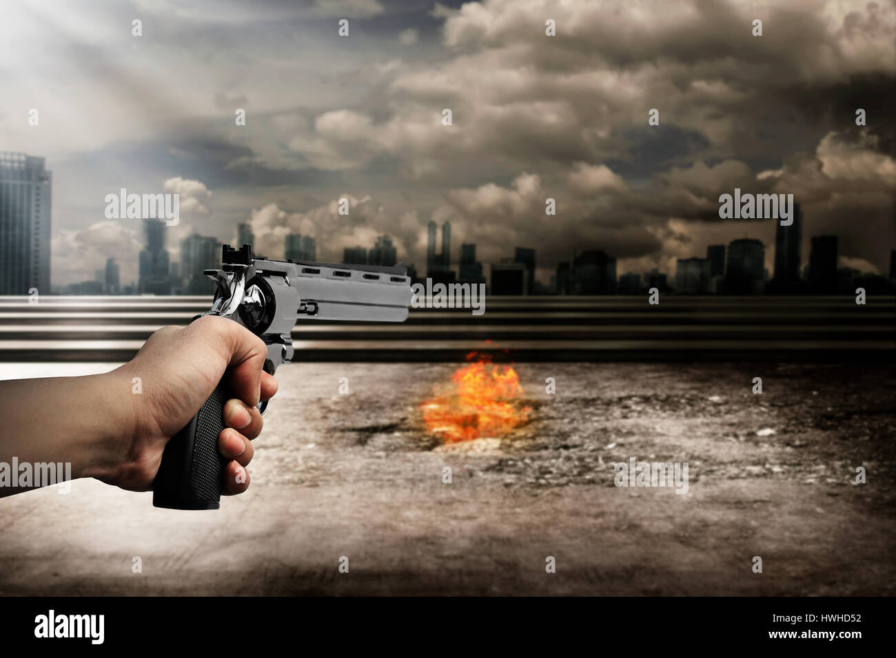 Man hand holding gun and aiming to the burn city Stock Photo - Alamy