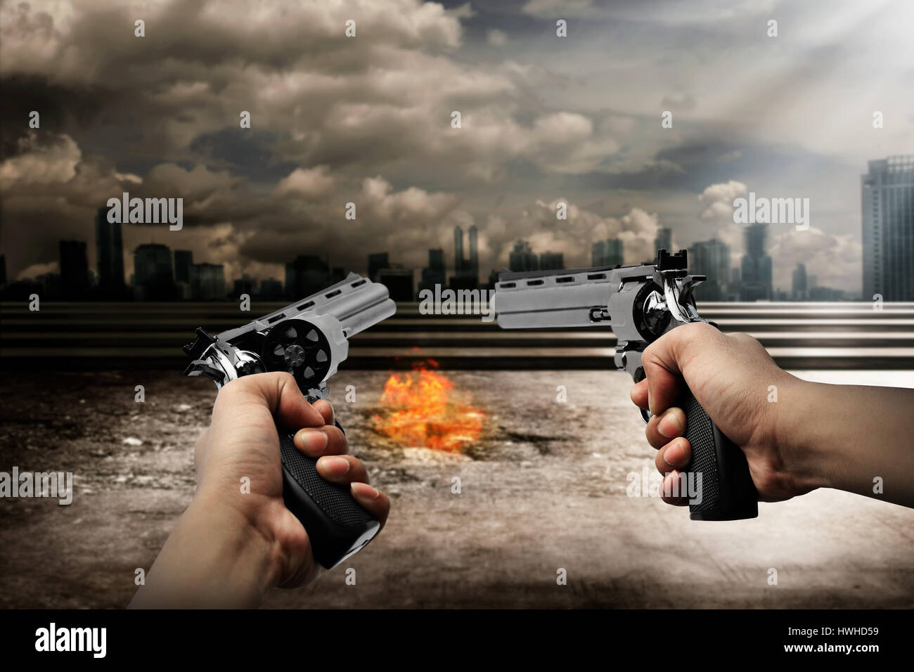 Man hand holding two gun and aiming to the burn city Stock Photo - Alamy