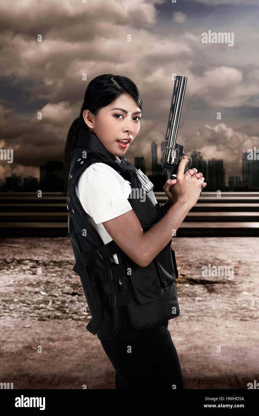 Beautiful police woman holding gun ready to fire Stock Photo - Alamy