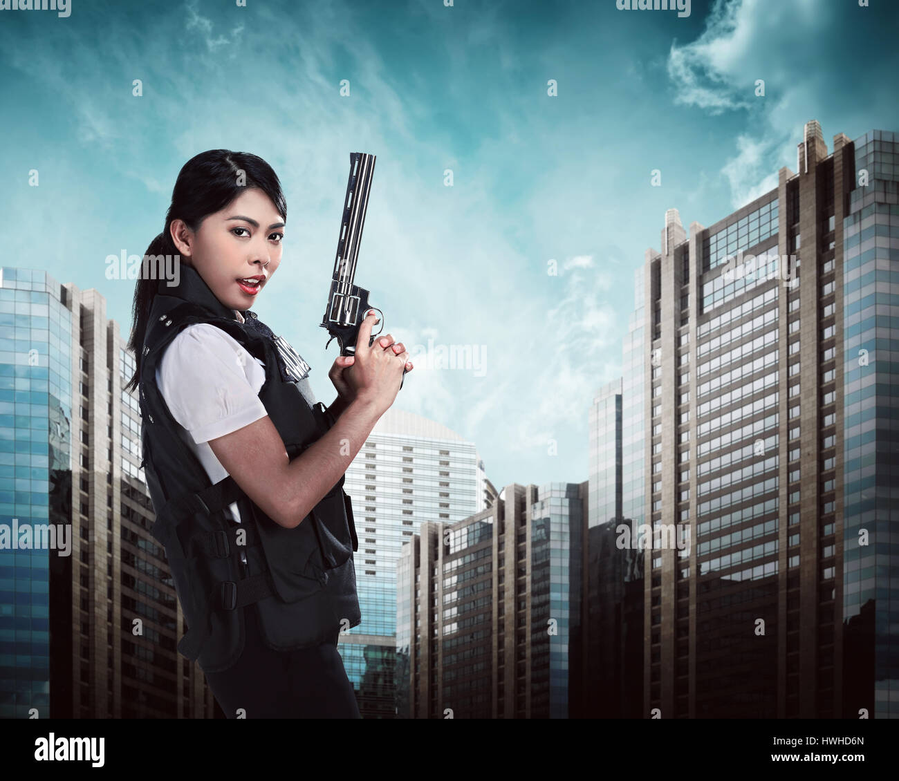 Beautiful police woman holding gun ready to fire Stock Photo - Alamy