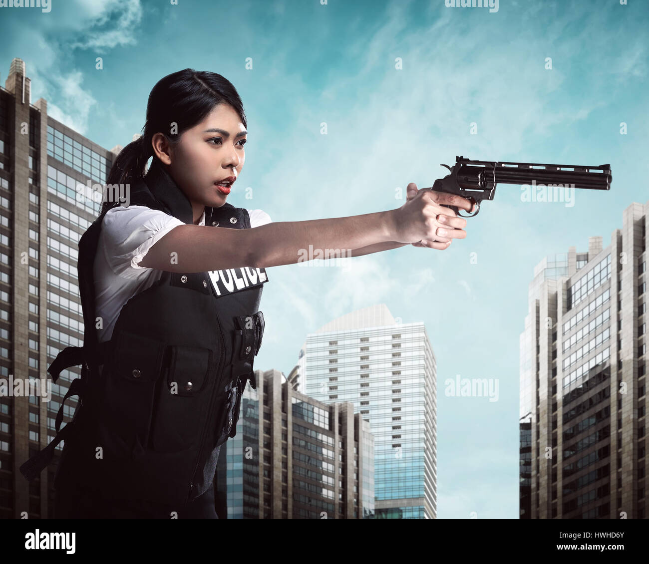 Beautiful police woman holding gun ready to fire Stock Photo - Alamy