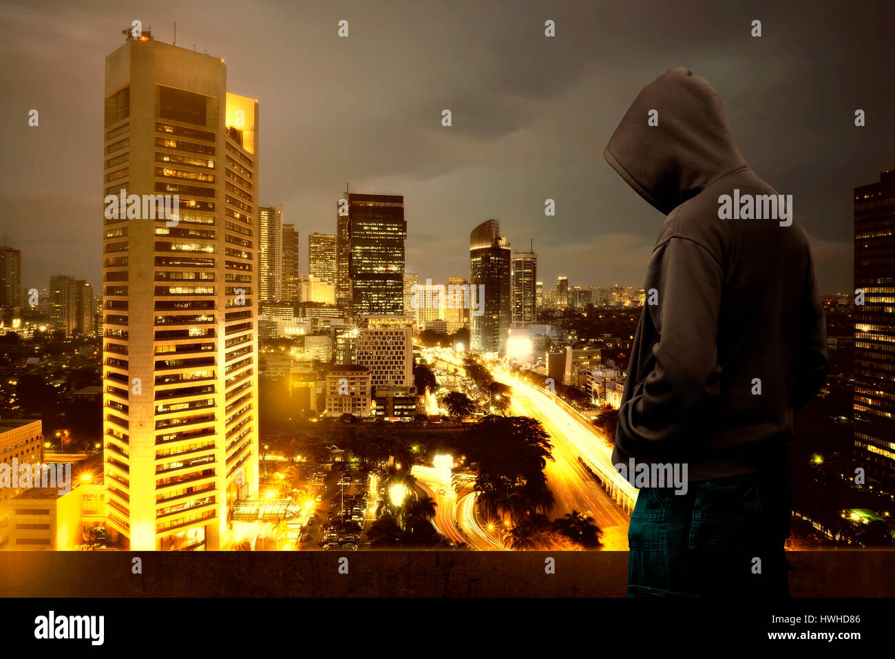 Computer hacker silhouette of hooded man standing on the top of the ...