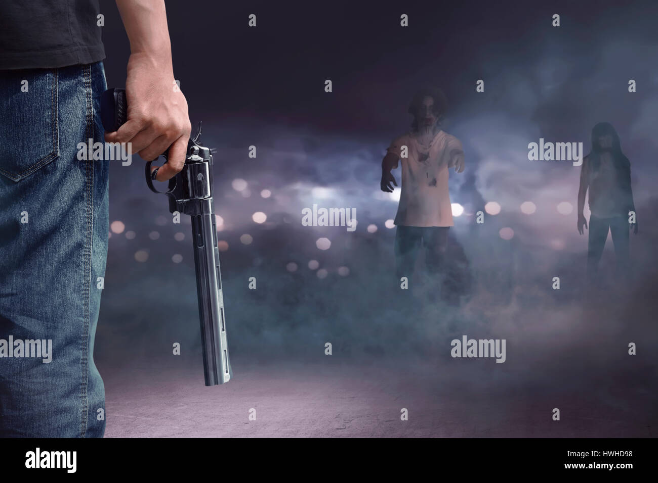 Brave man with jeans pants holding gun looking at zombies walking into ...