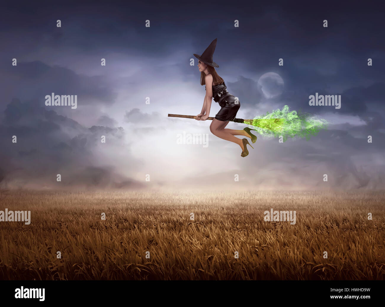 Asian witch using broom flying over meadow field Stock Photo - Alamy