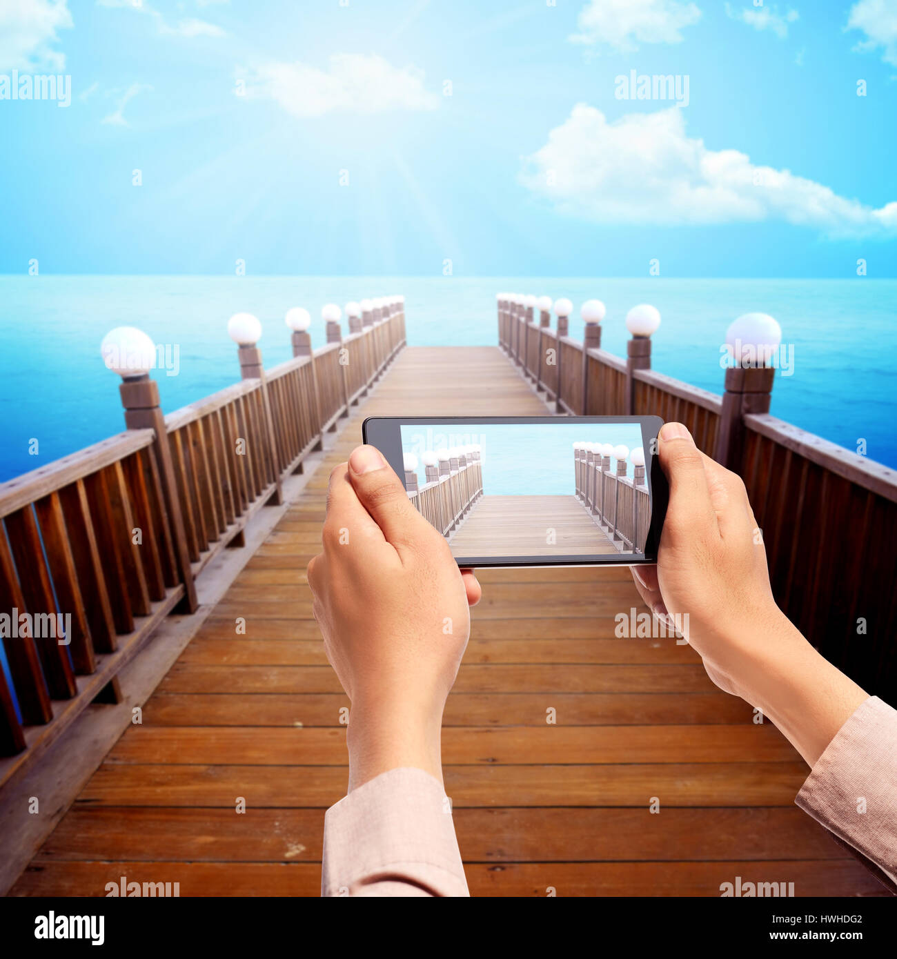 Man hand take picture of wooden pier using cellphone. Tourism concept ...
