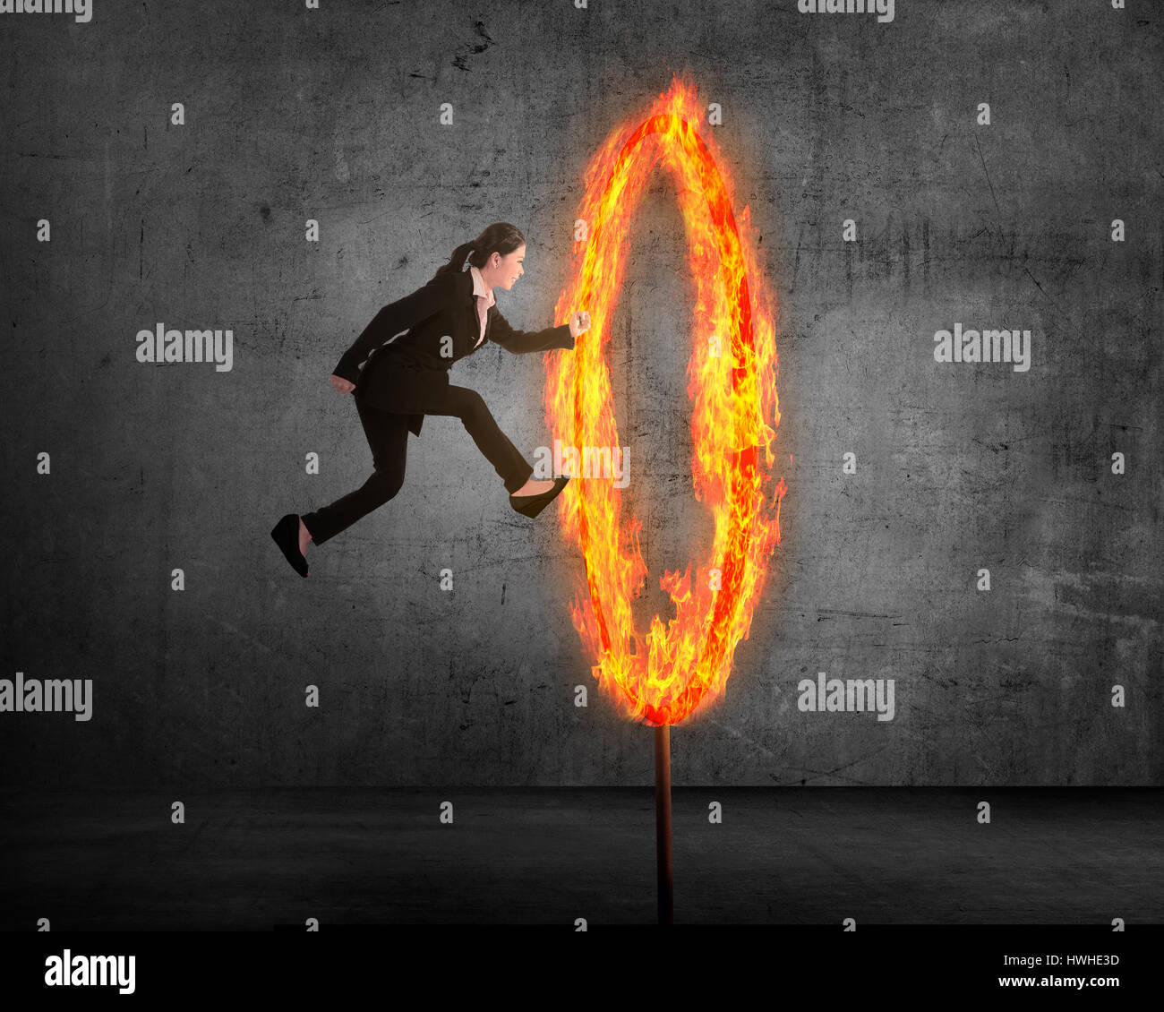 Asian business person jumping through ring of fire. Business risk ...