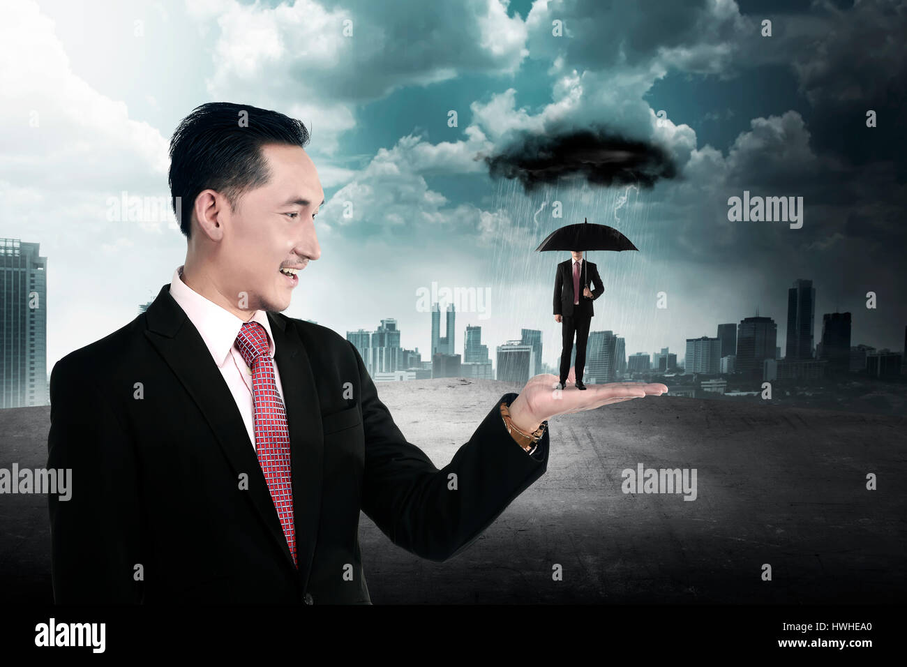 Business man holding small man using umbrella to protect himself from ...