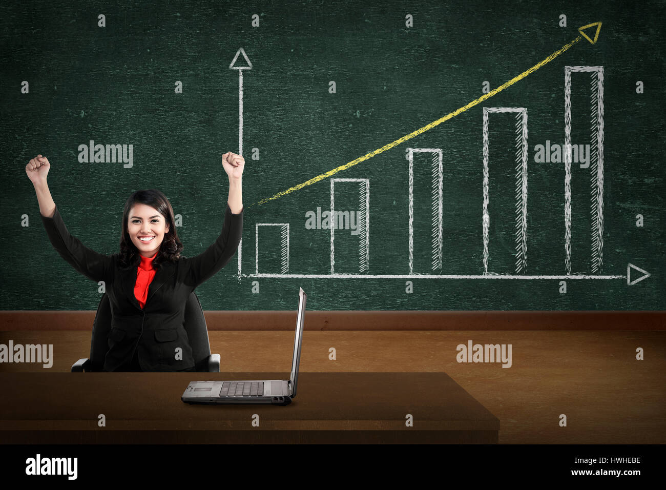 Business person smile over increasing graph drawing on chalk board ...