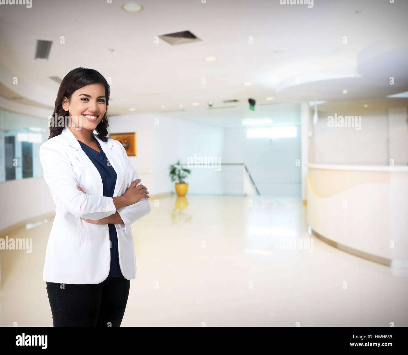 Pretty female doctor posing with hospital background Stock Photo - Alamy