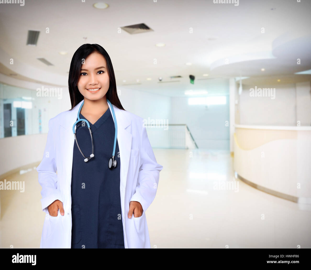 Pretty female doctor posing with hospital background Stock Photo - Alamy