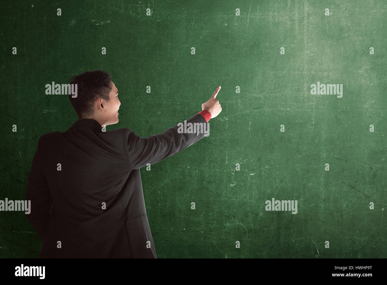 Business man show something with chalkboard background. you can put ...