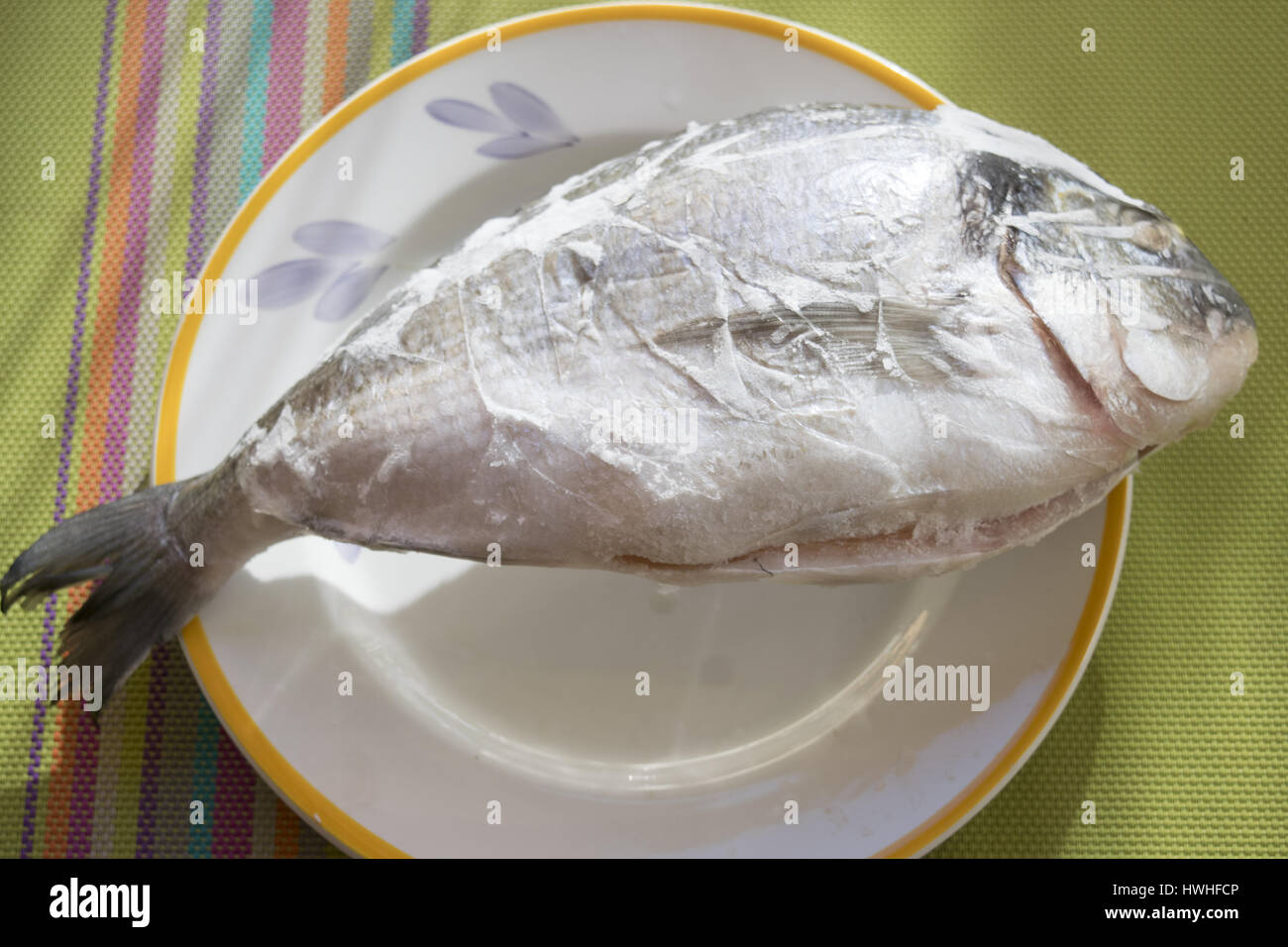 frozen sea bream on a white dish Stock Photo - Alamy