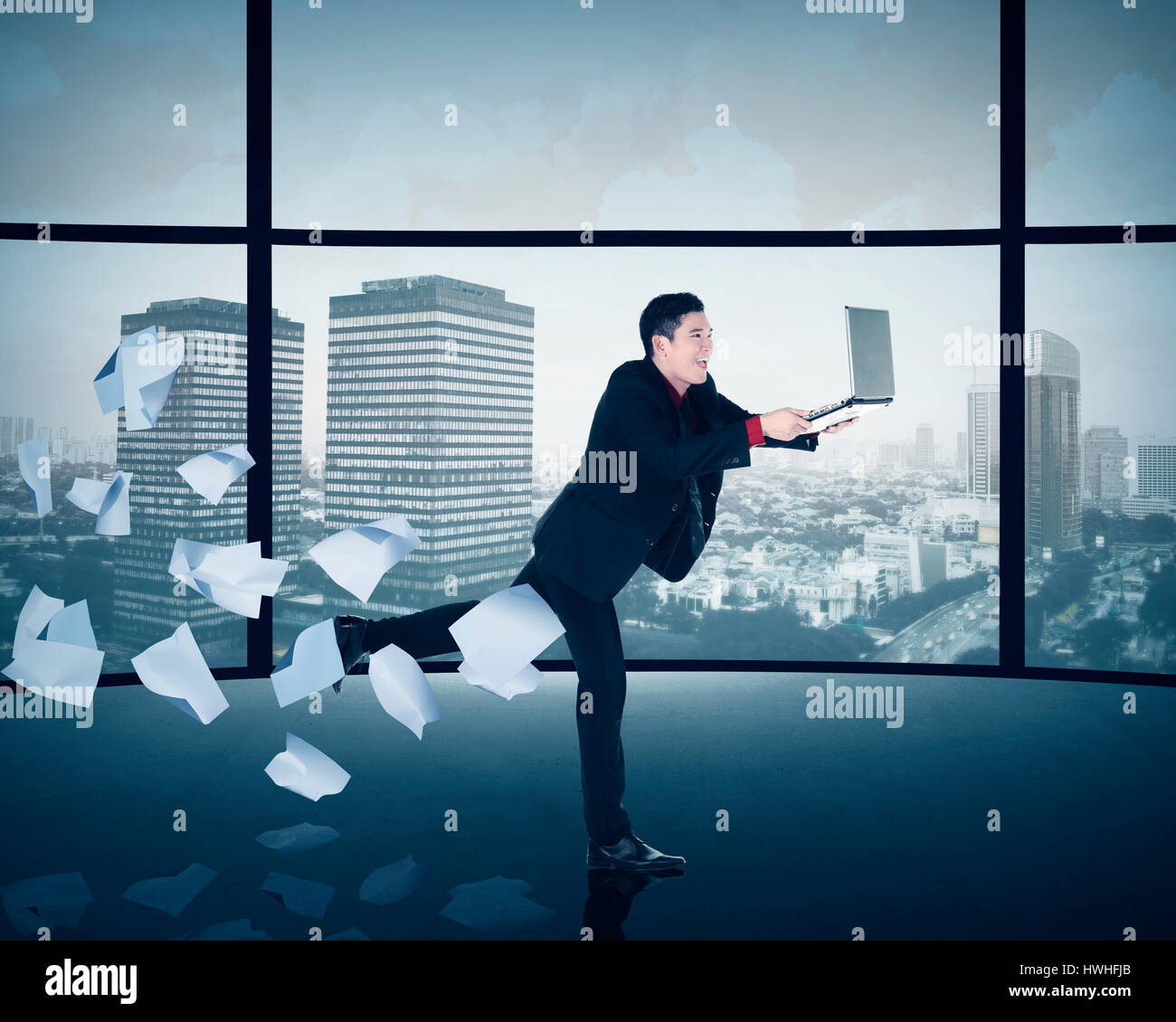 Asian business man running with laptop inside office building Stock ...