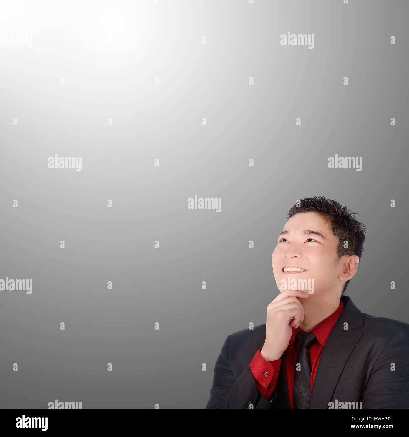 Asian business man thinking over grey background Stock Photo - Alamy