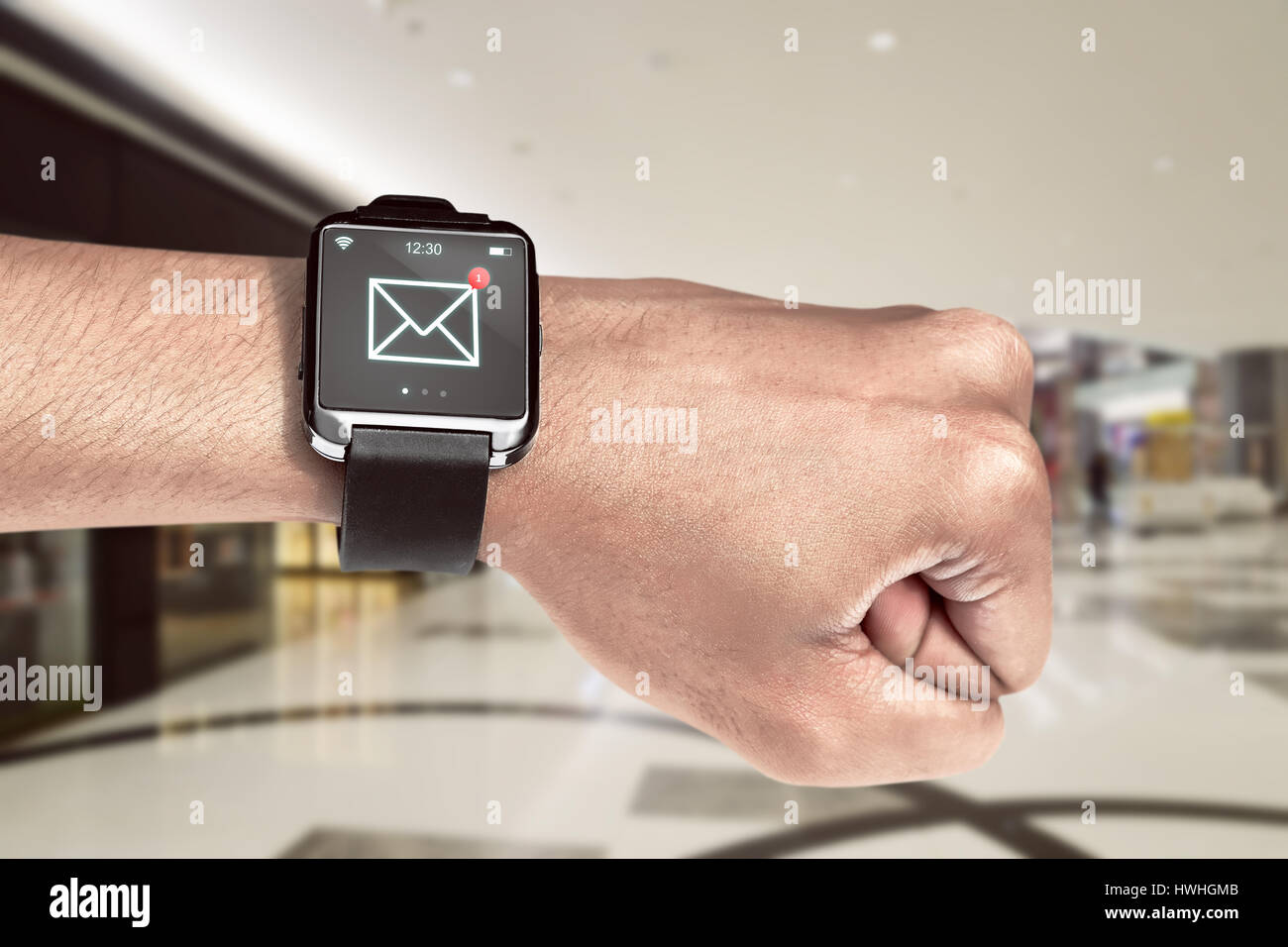 Close up smart watch with unread message icon on the screen is on hand ...