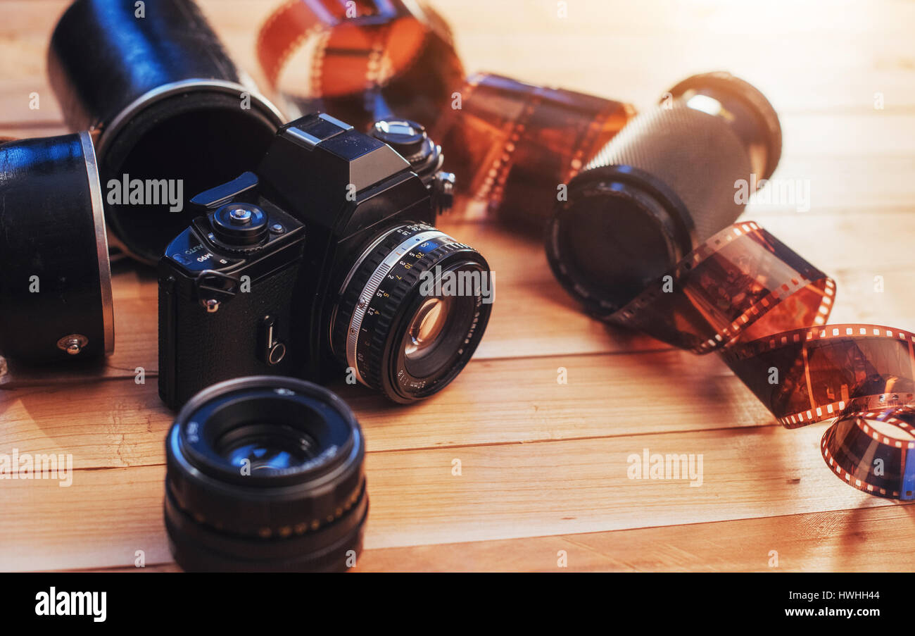 Old film camera and a roll of film on wood Stock Photo - Alamy