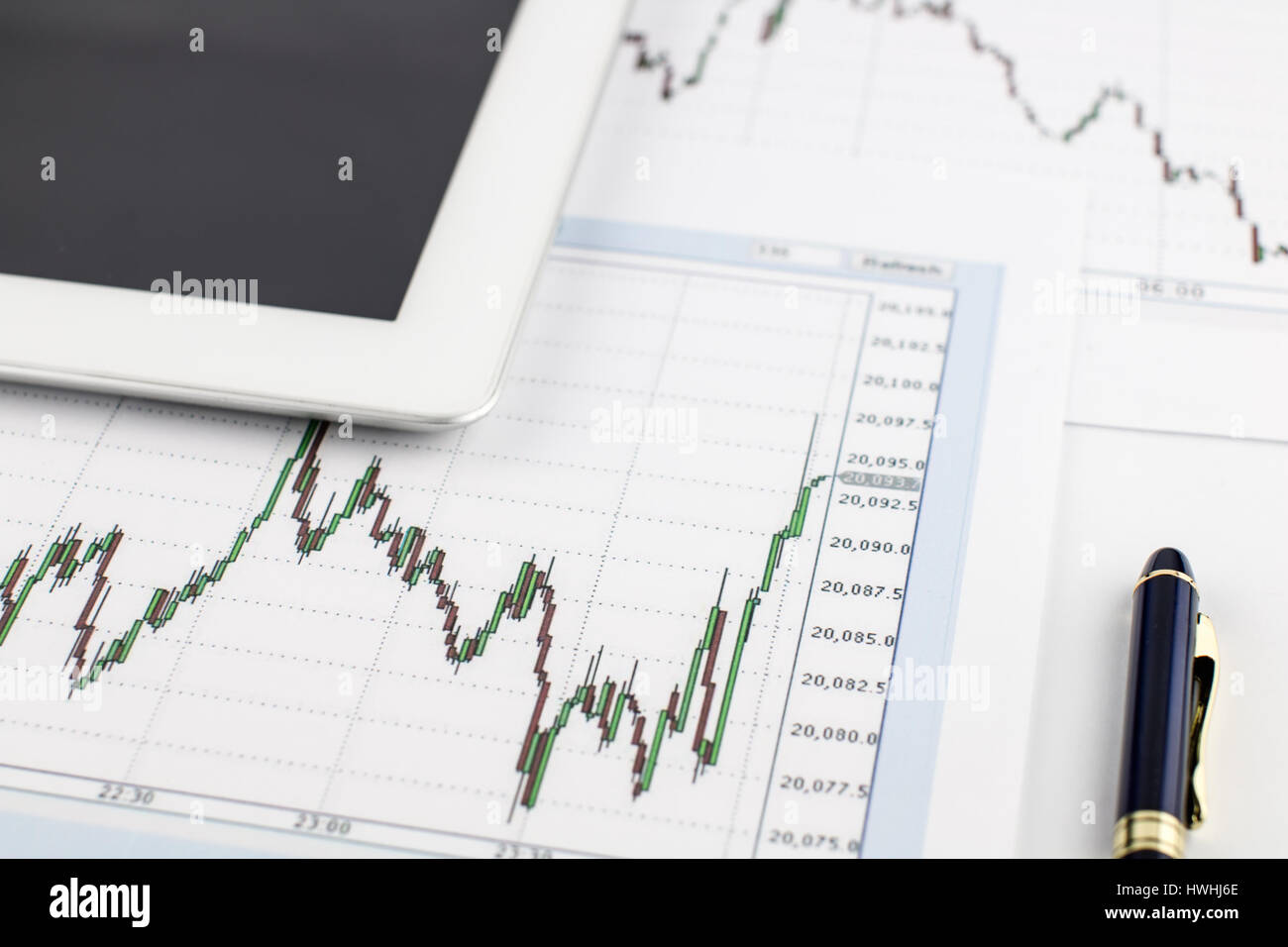 Tablet computer, the Dow Jones chart and pen on a white background ...