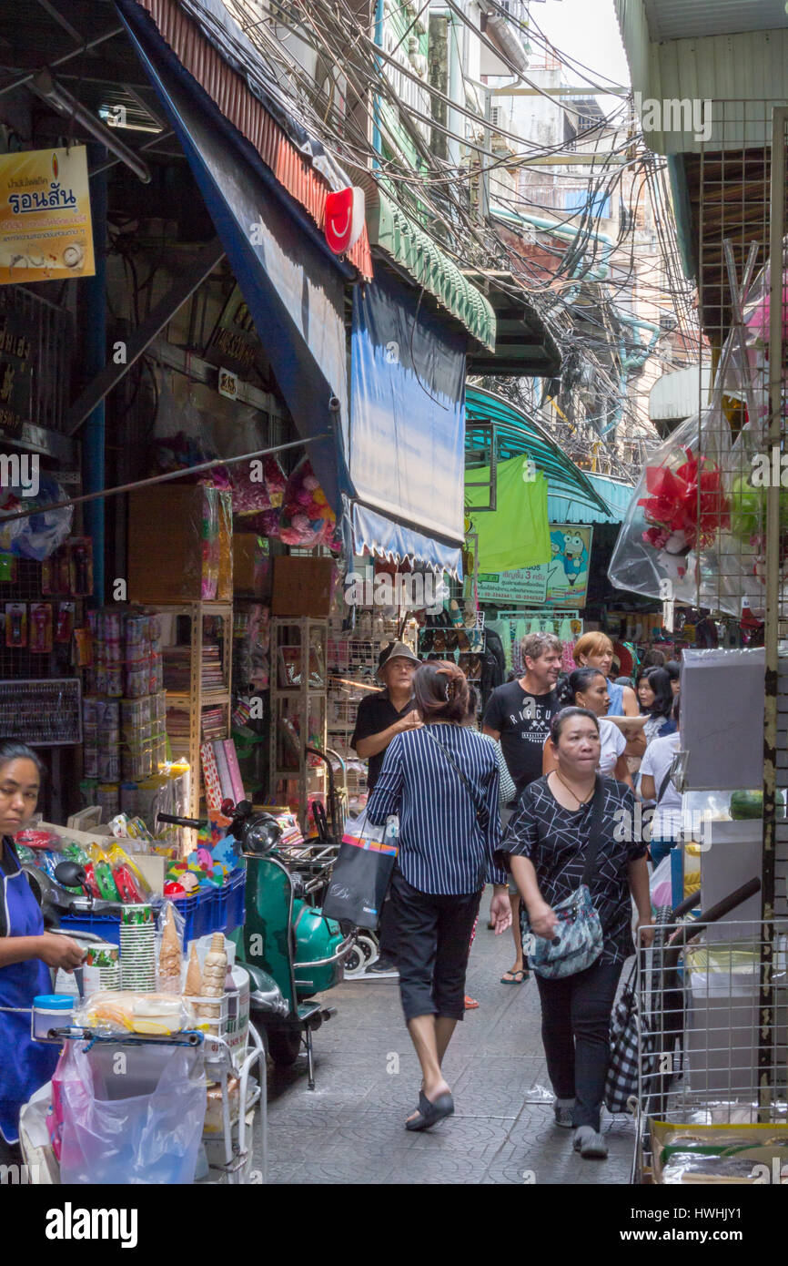 Tourists and locals shopping in Sampeng Lane in Bangkok's Chinatown ...