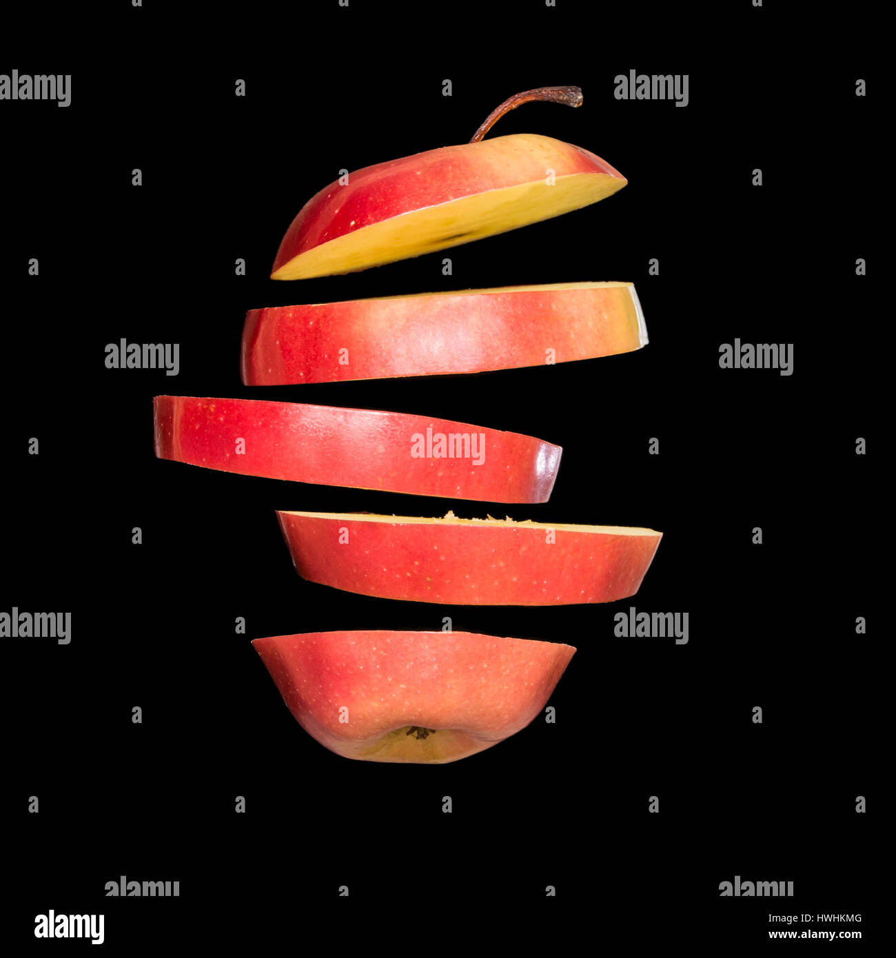 Flying apple. Sliced red apple isolated on black background. Levity ...