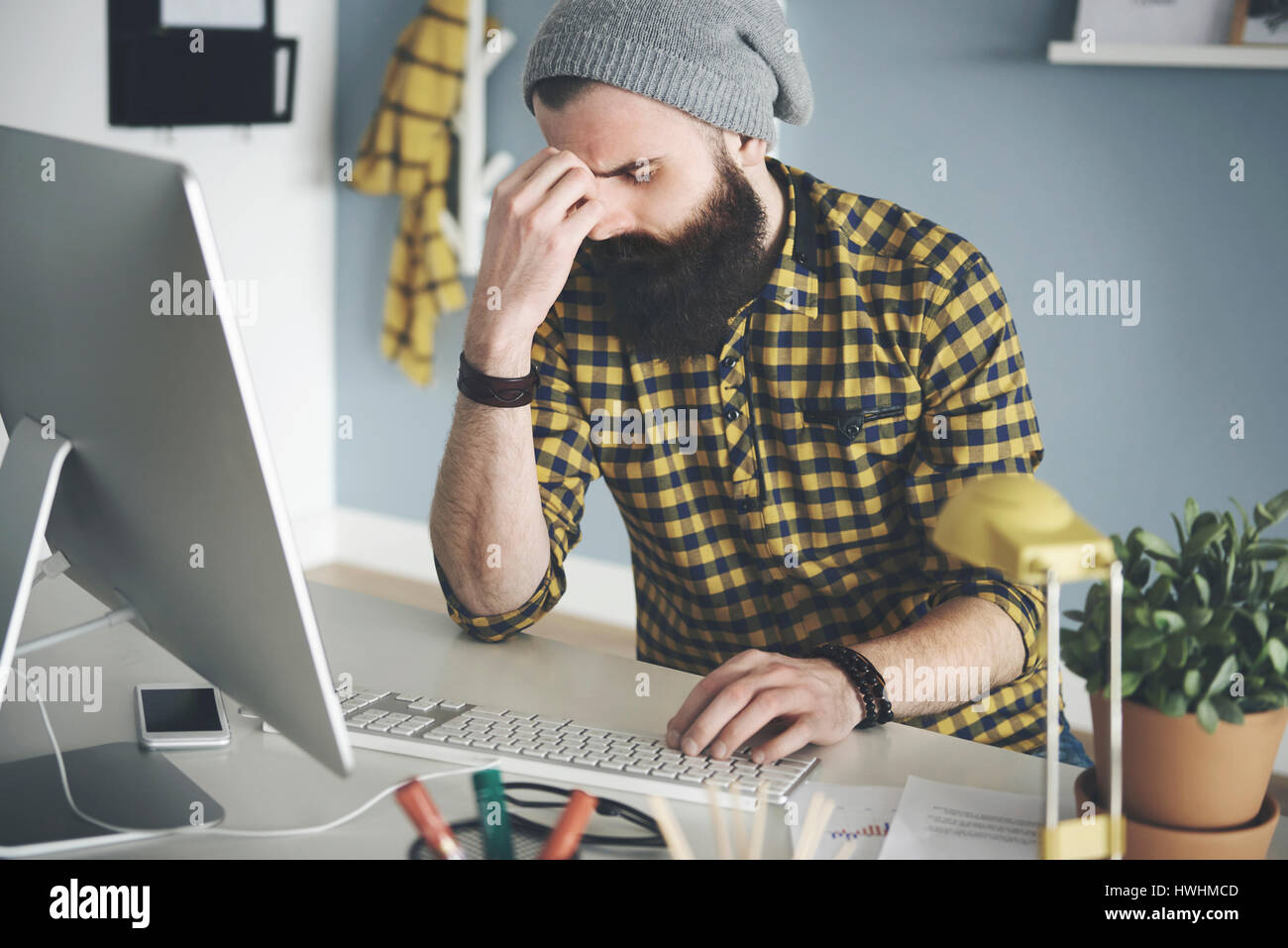 Frustrated young man at computer desk Stock Photo - Alamy