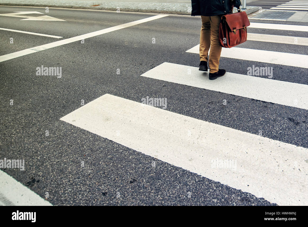 Unrecognizable businessman walking over pedestrian zebra crossing on ...