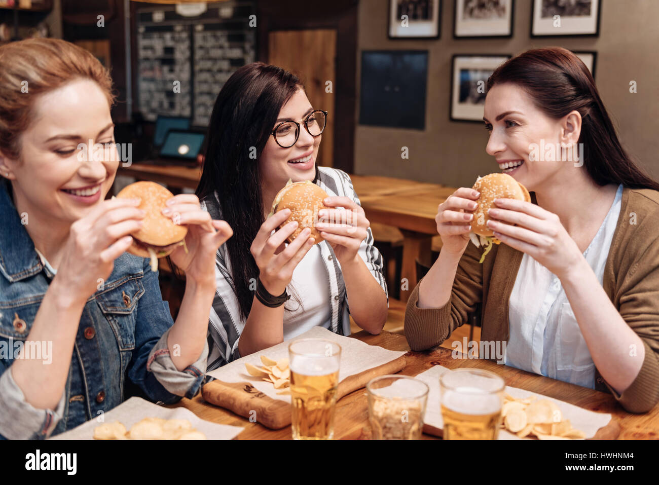 Great for supper. Three best friends holding tasty food in hands ...