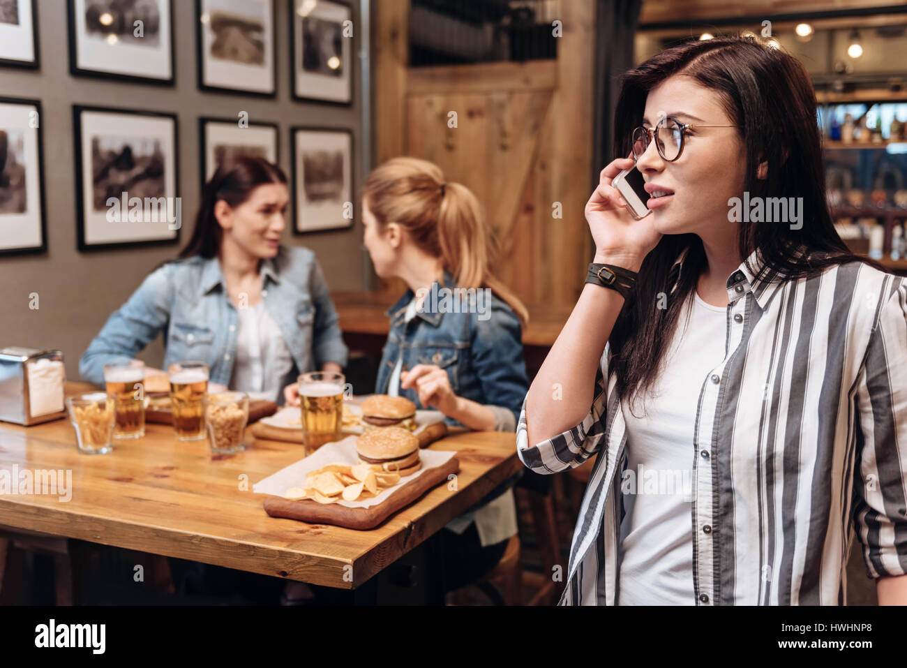 Call me later. Pretty brunette wearing stylish glasses holding her ...