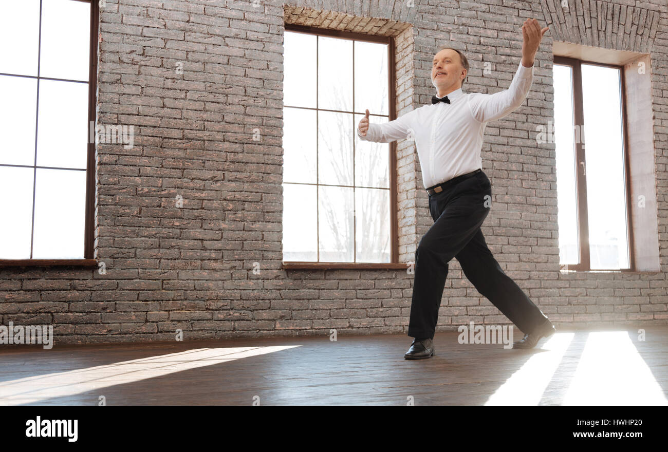 Full of inspiration. Charming delighted talented senior man performing ...