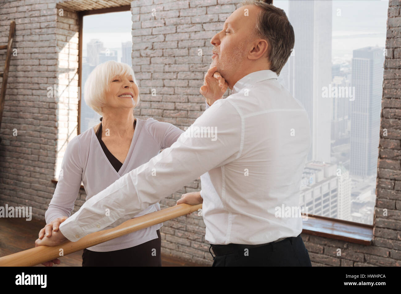 Creating ideal posture. Delighted skilled senior couple performing in ...