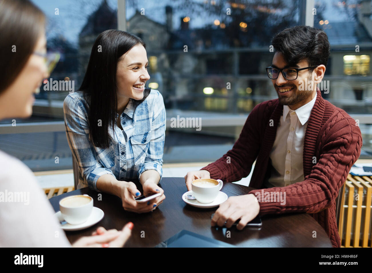 Carefree friends or colleagues talking by cup of coffee in cafe Stock ...