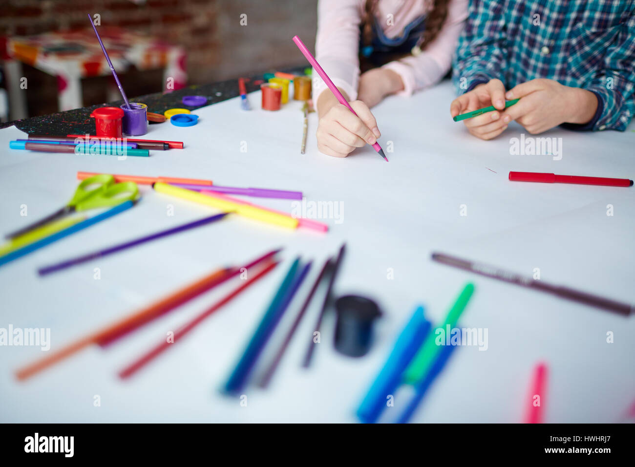 Hands of children with crayons drawing on paper Stock Photo - Alamy