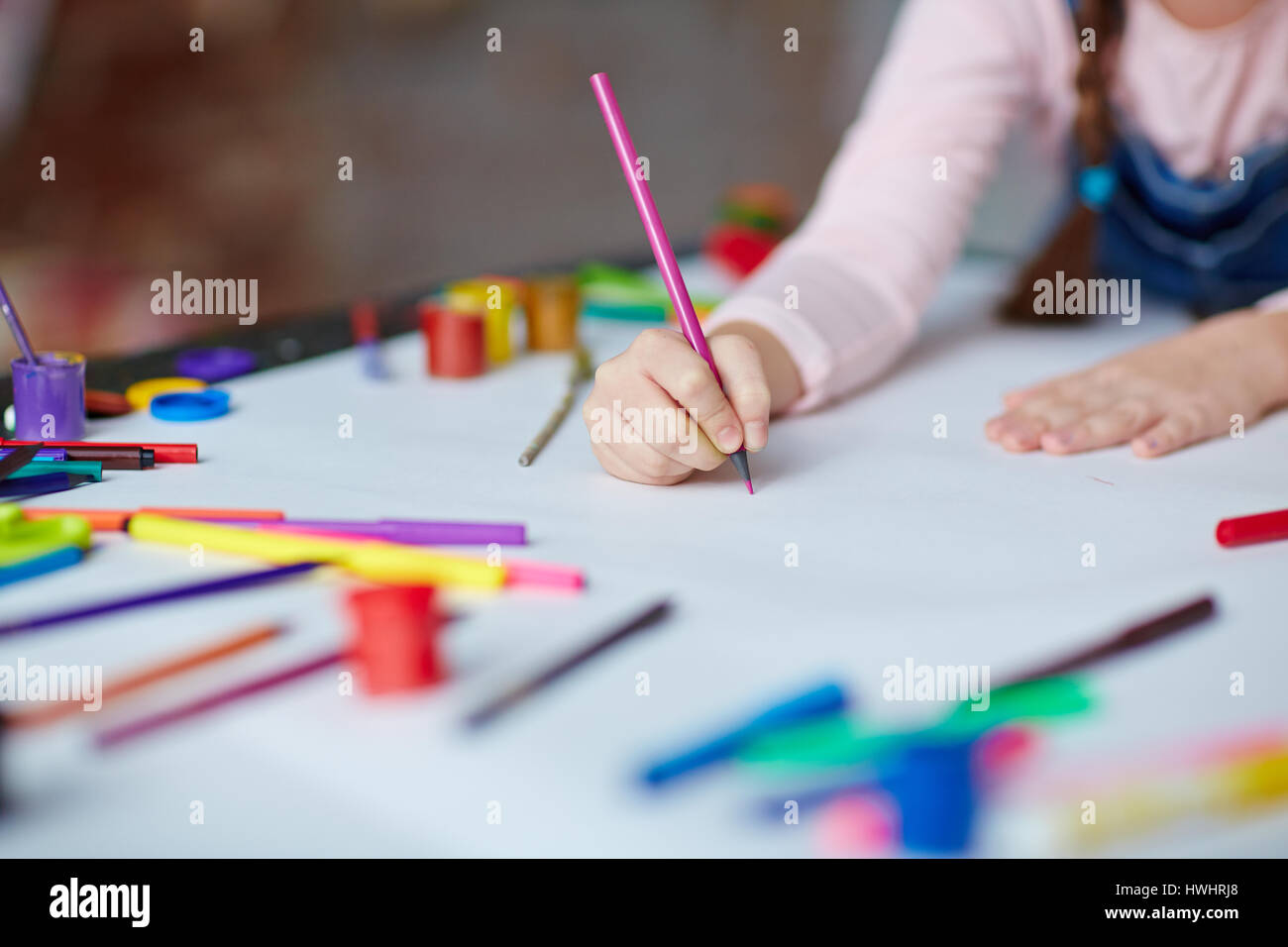 Little girl holding crayon or highlighter on paper Stock Photo - Alamy