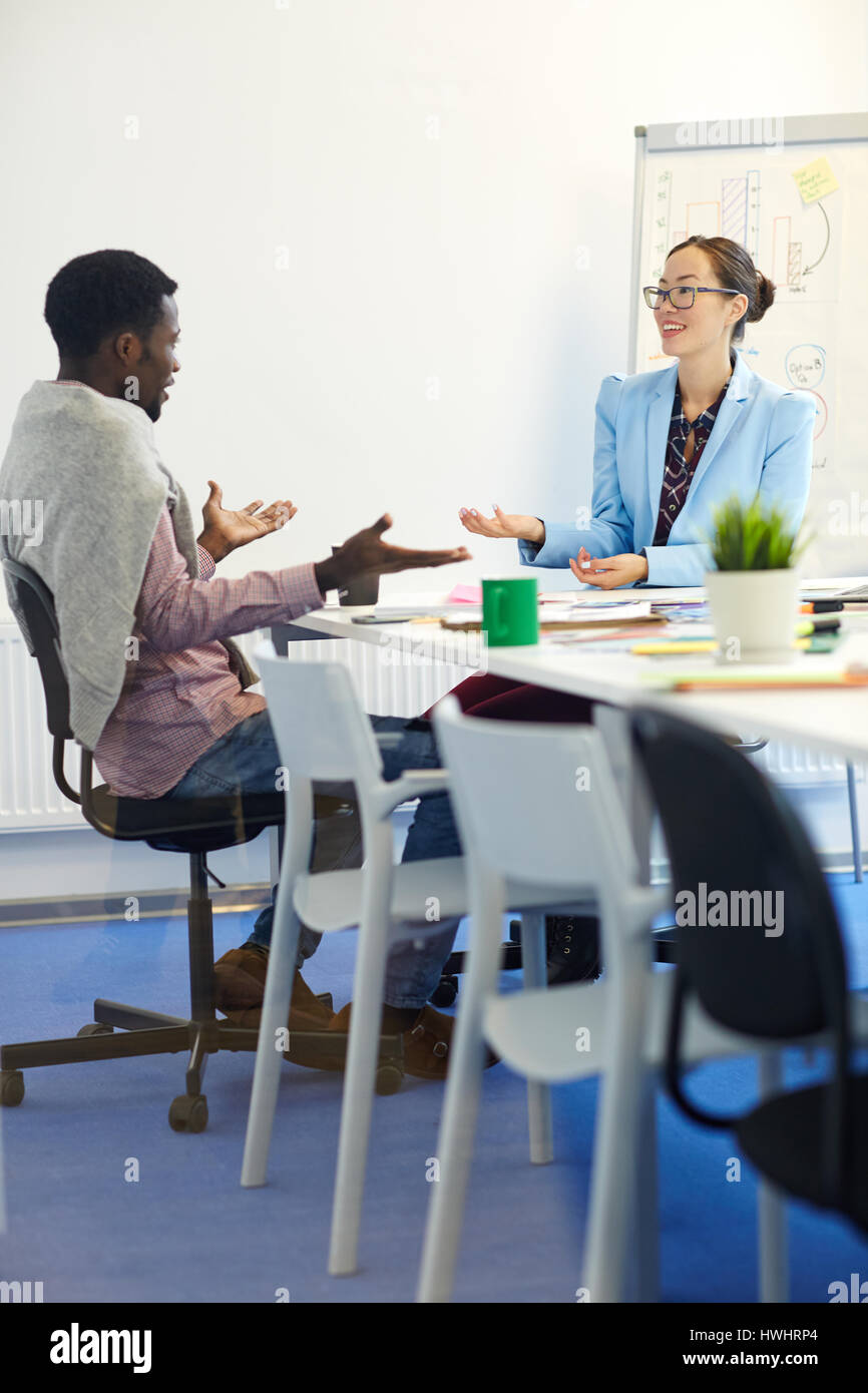 Intercultural colleagues discussing working moments Stock Photo - Alamy