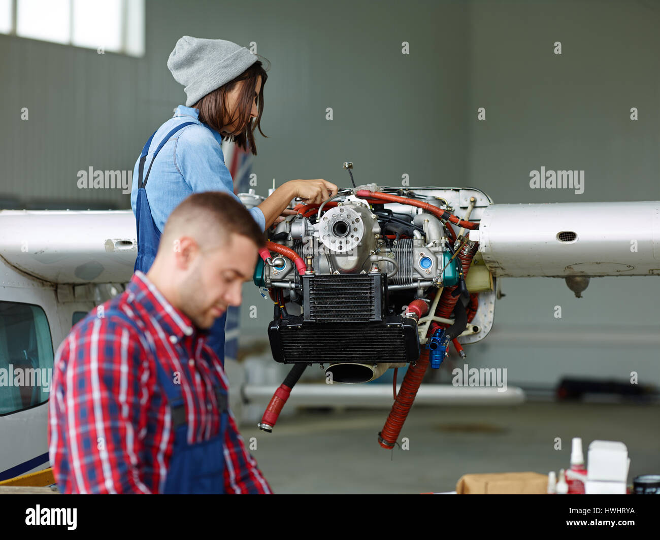 Female engineer with wrench repairing motor of jet Stock Photo - Alamy