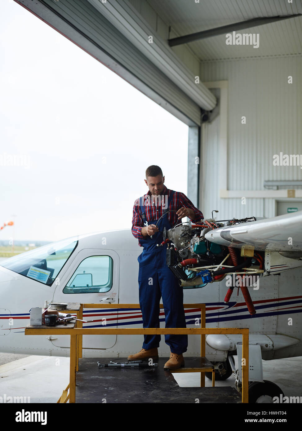 Airplane technician repairing engine in hangar Stock Photo - Alamy