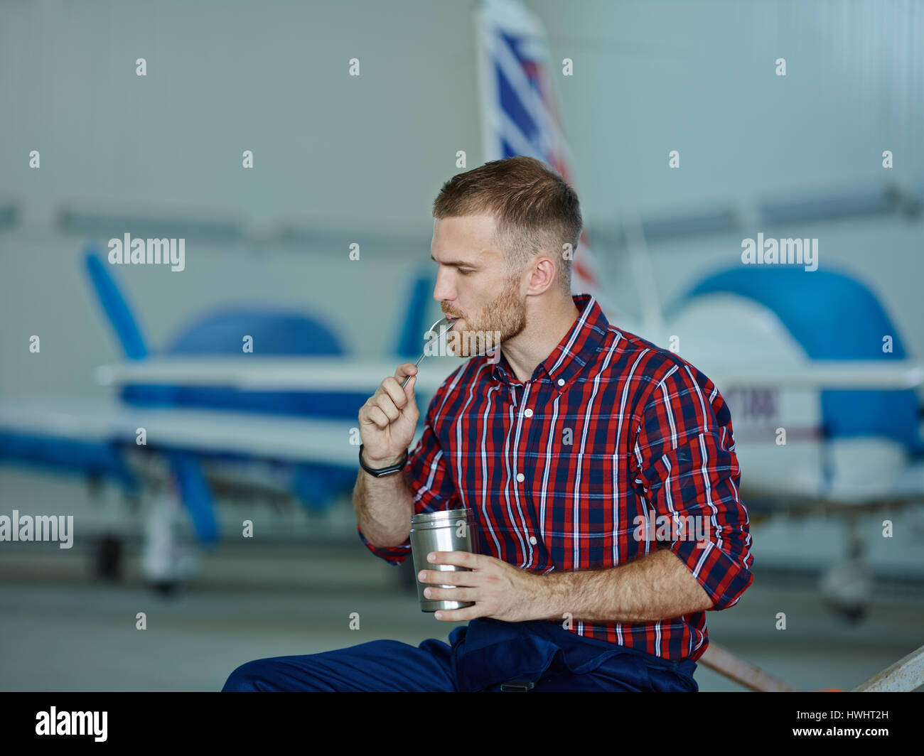 Young engineer with container enjoying lunch in the middle of working ...