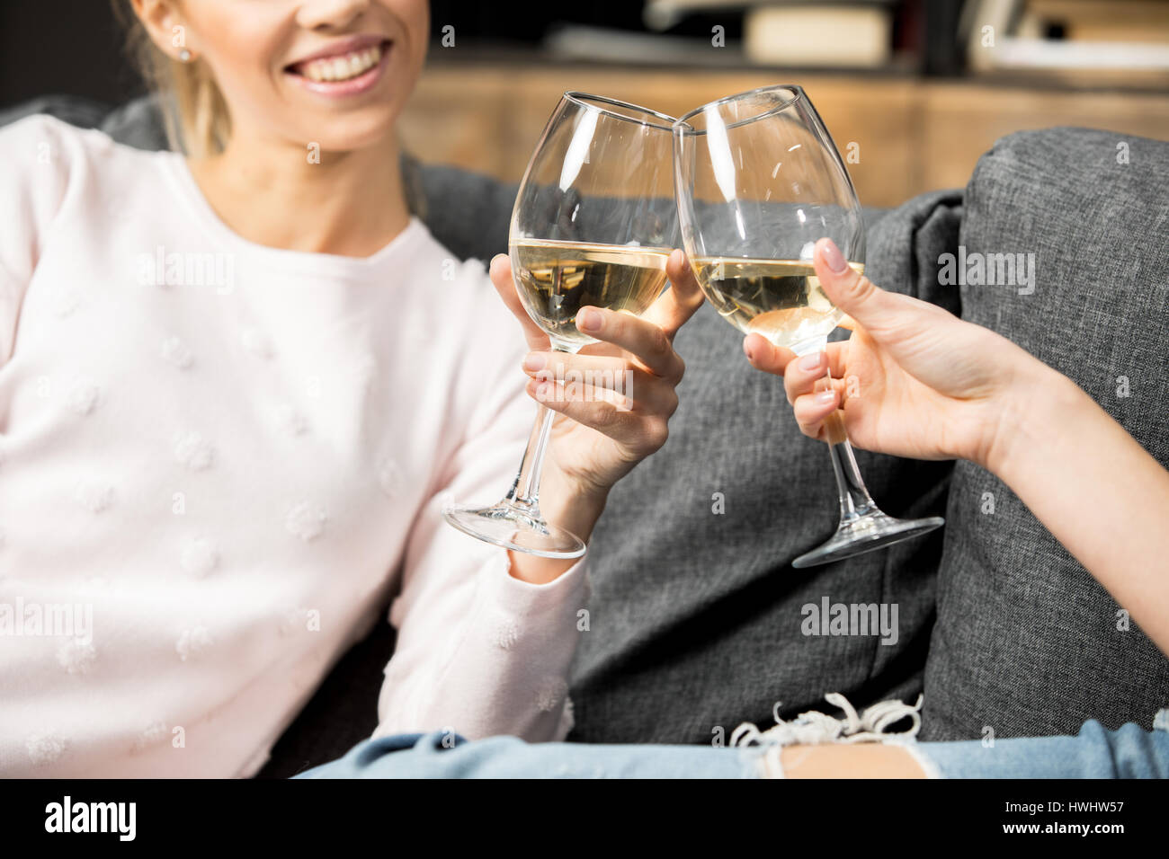 Partial view of female friends cheering with white wine Stock Photo - Alamy